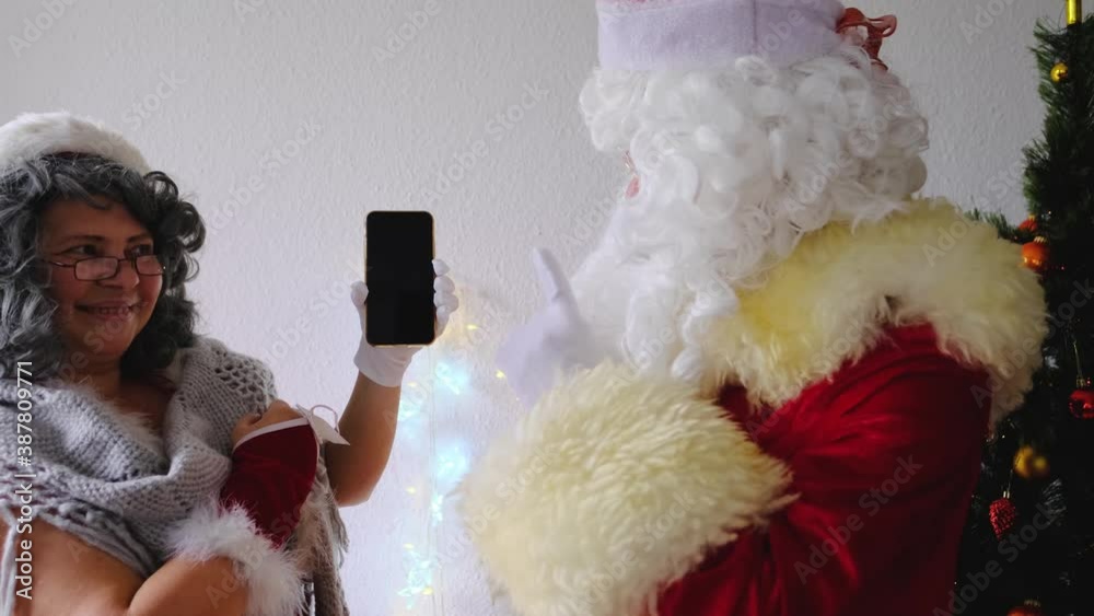 elderly santa claus with his wife congratulates children and adults ...