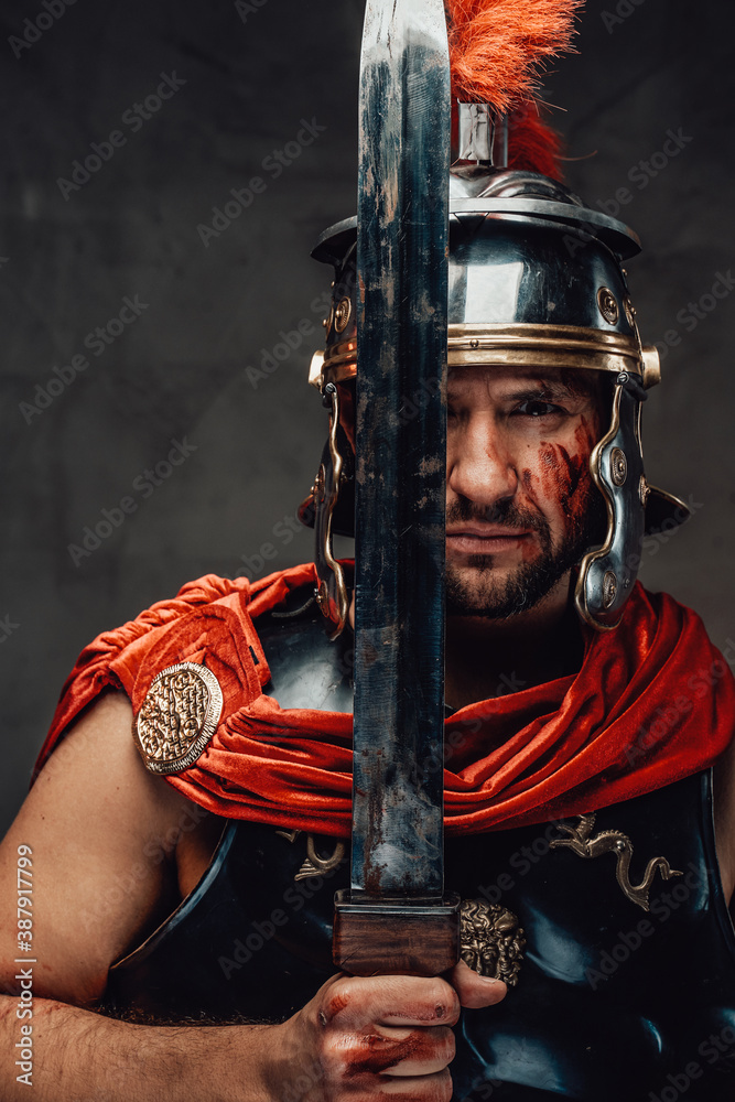 Serious military roman with dark armour and helmet posing using his ...