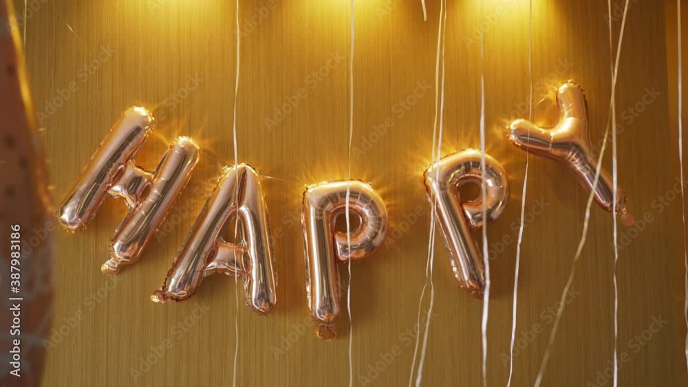 Word Happy made with golden shiny air balloon letters hanging on orange ...