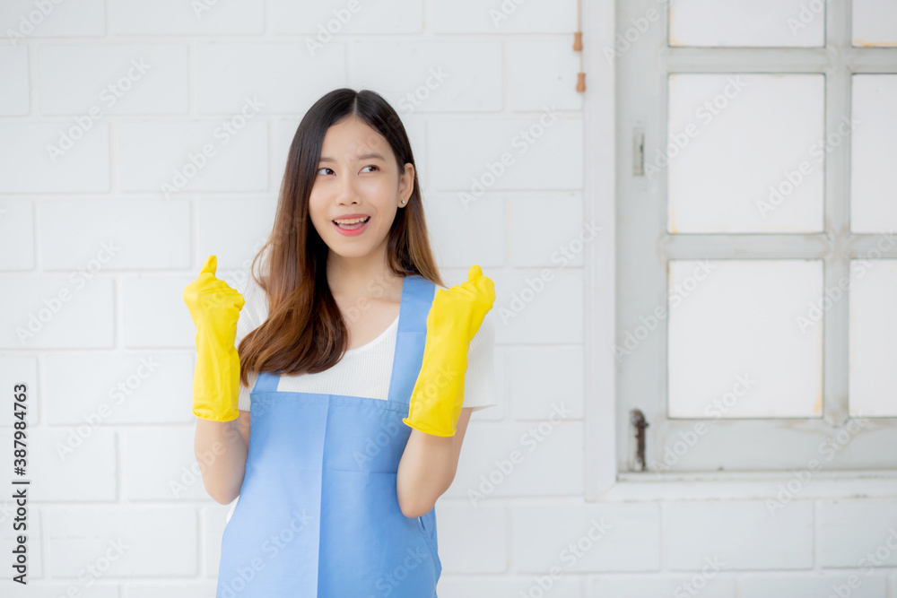 Portrait young asian woman is housekeeper in rubber gloves and apron ...