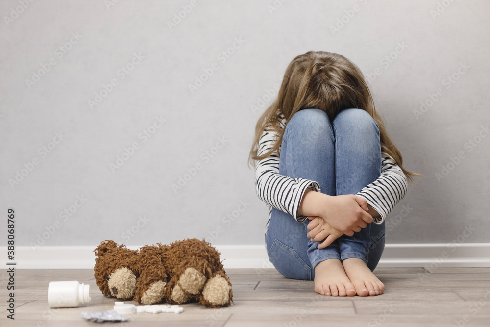 Sad teenager girl, schoolgirl in depression sits on the floor near the ...
