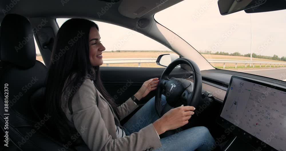 Side view of young happy Caucasian woman traveling in self-driving ...
