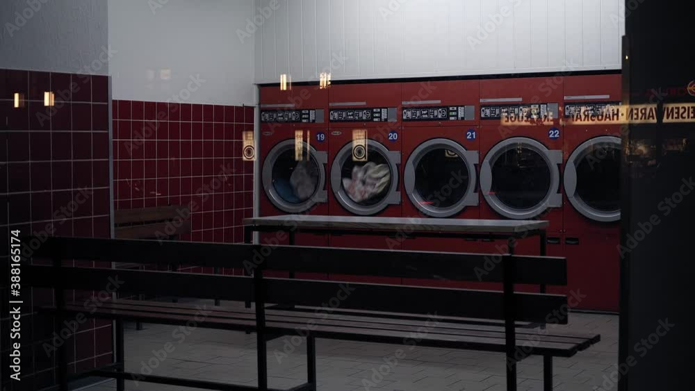 Shot of empty deserted self-service laundry shop at night, two laundry ...