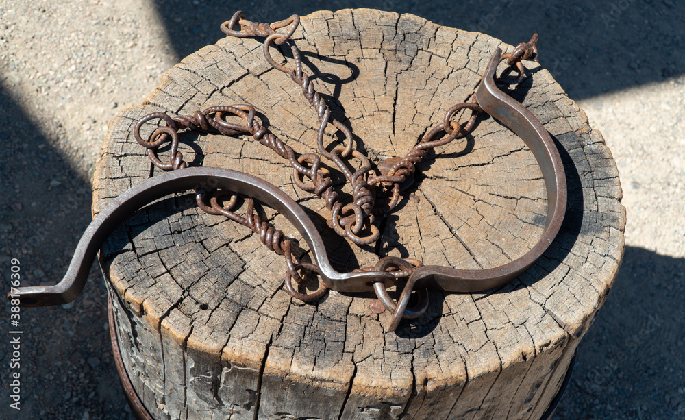 old, iron shackles on a wooden block. tool for slavery. tool for ...