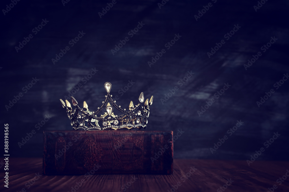 low key image of beautiful queen/king crown on old book. vintage ...
