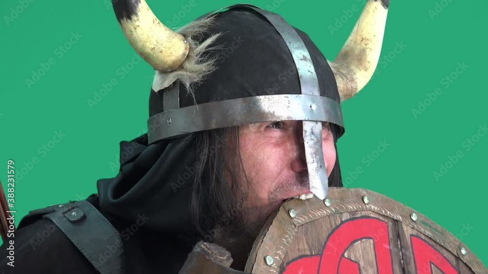 Aggressive viking warrior scares enemies by biting with crooked teeth ...