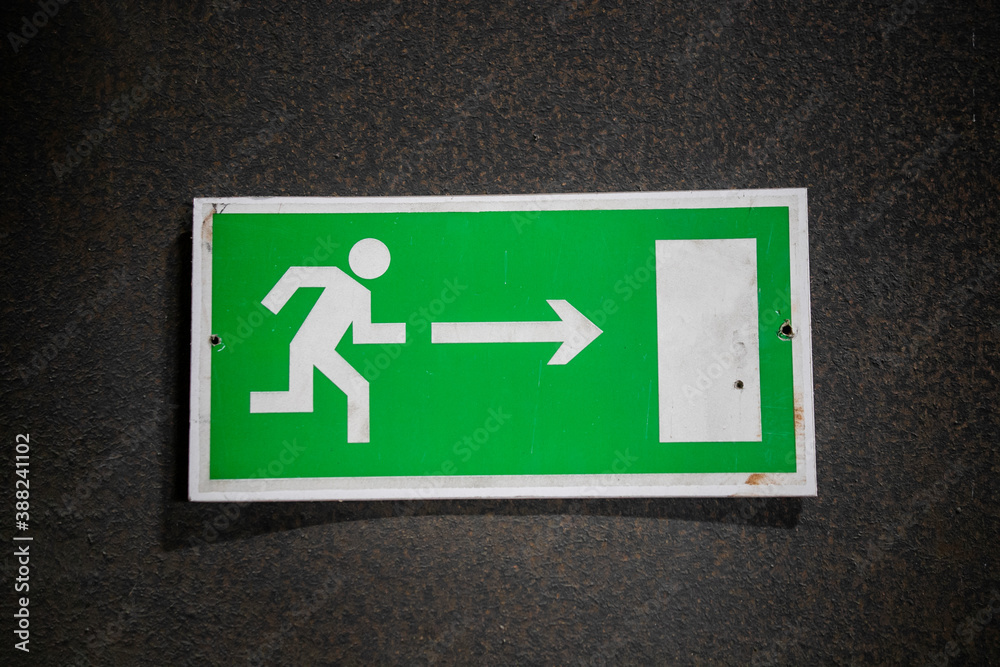 Emergency exit sign, escape sign on the wall. Safety sign in office ...