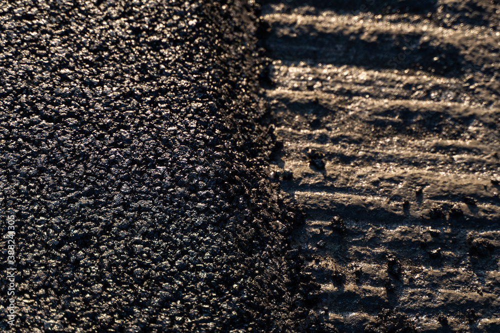 Freshly laid black bitumen asphalt with a high edge to the gravel ...