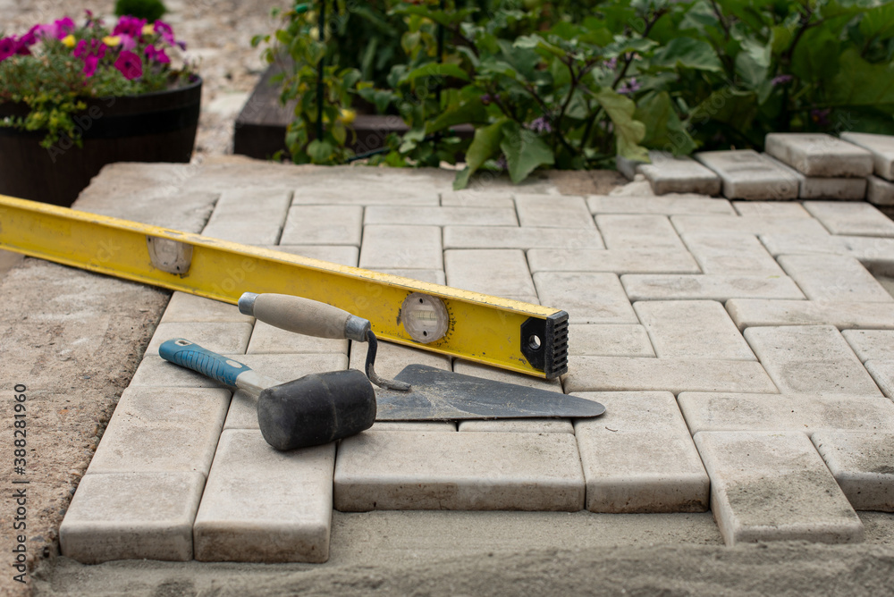 The master lays paving stones in layers. Garden brick pathway paving ...