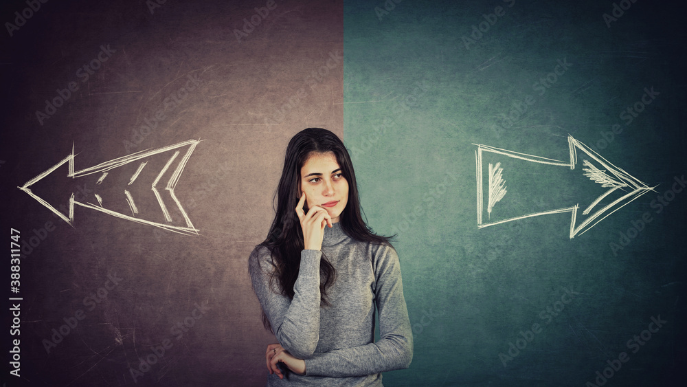 Curious and doubtful young woman, has to choose right or left side ...