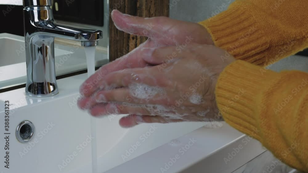 Wash hands with soap under a tap with water, foam hands, wash off dirt ...