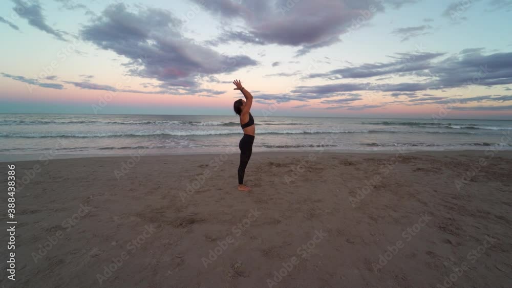 Vidéo Stock Woman practice yoga at beach sunset with waves, beautiful ...