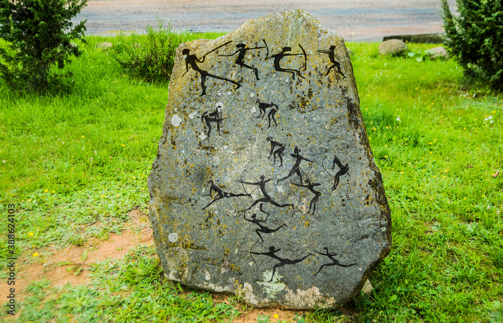 Figure animals and hunters on the stone wall of the cave of ocher paint ...