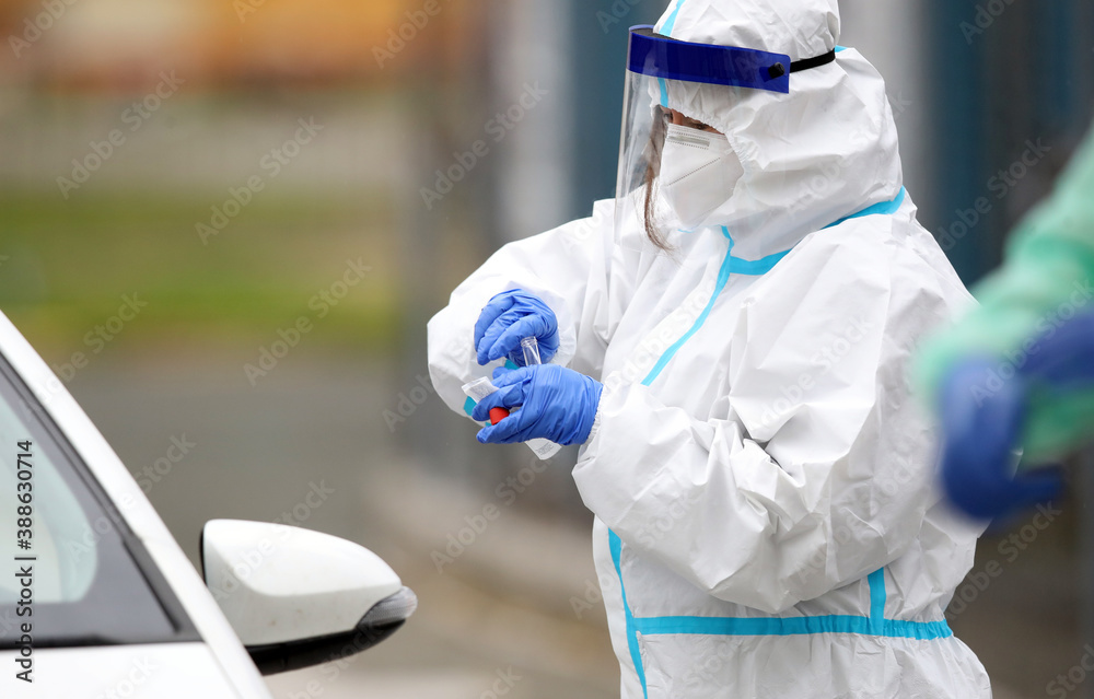 Medical staff member with mask and protective equipment performs ...
