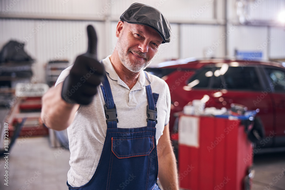 Handsome mechanic giving thumbs up and smiling Stock Photo | Adobe Stock