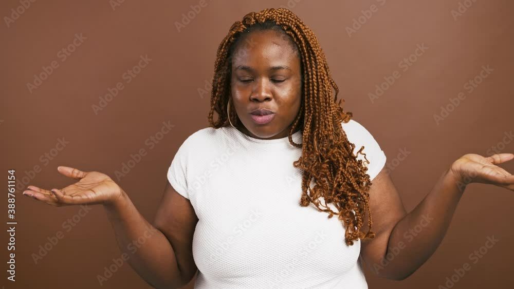 Emotional incomprehensible black woman shrugging shoulders and raising ...