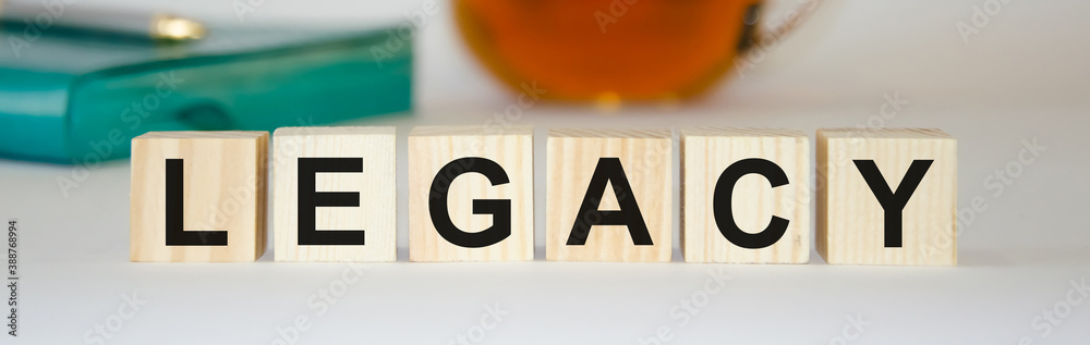 legacy - written on wooden cubes, tea and notepad in the background ...