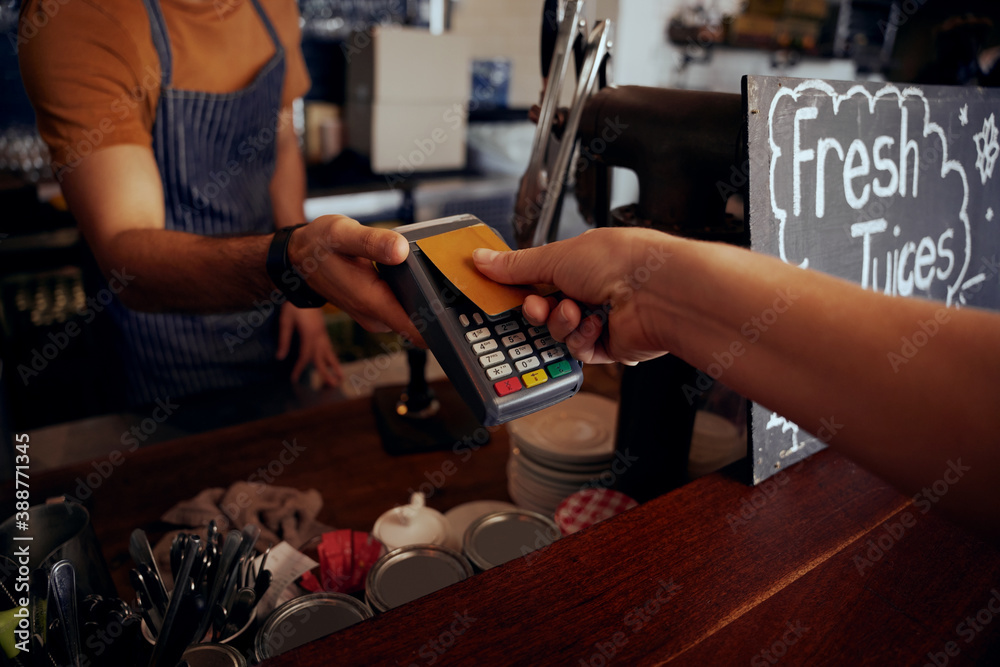 Female hands holding card against nfs payment machine to make payment ...