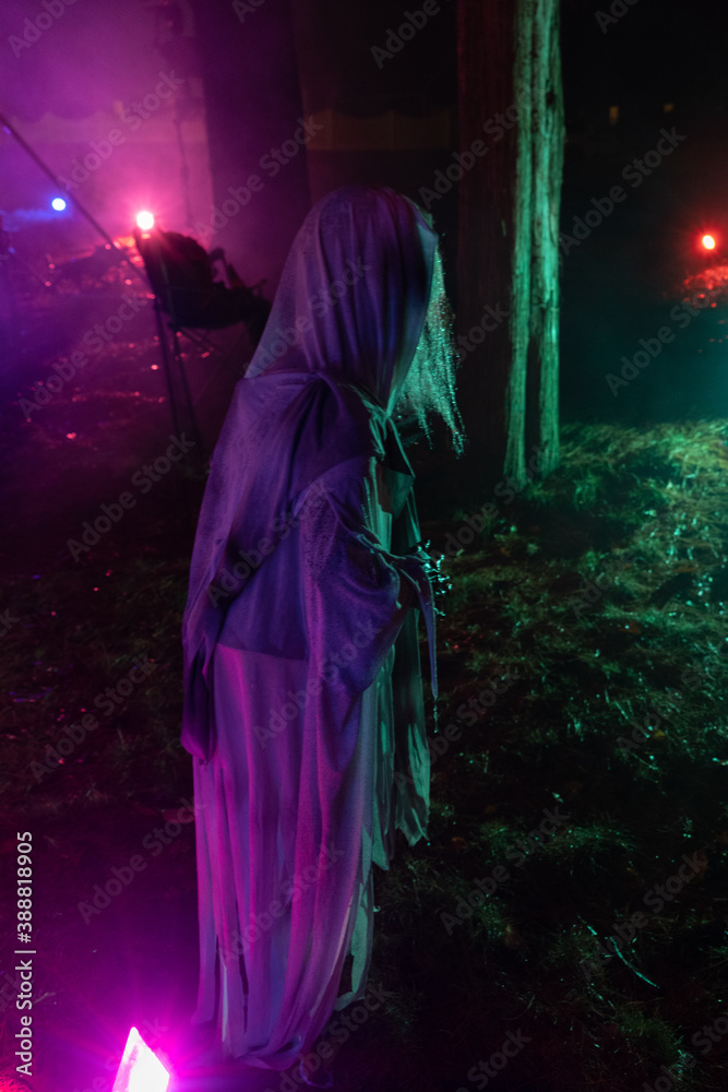 Old crone from the side lit by terrifying pink light with gnarled hands ...