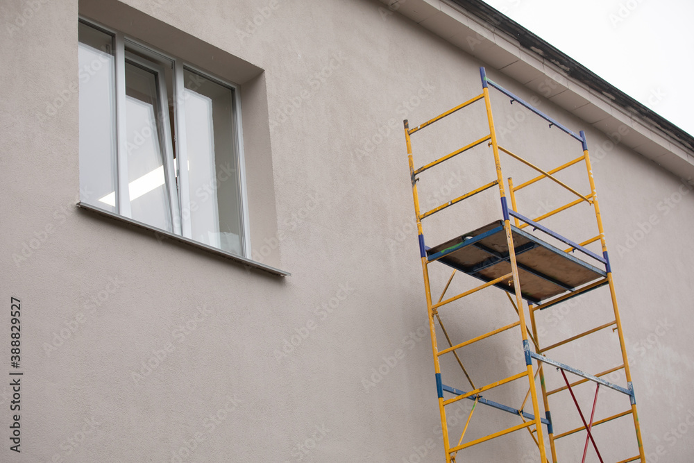 Outside repair and renovation of a apartment house using blue paint ...