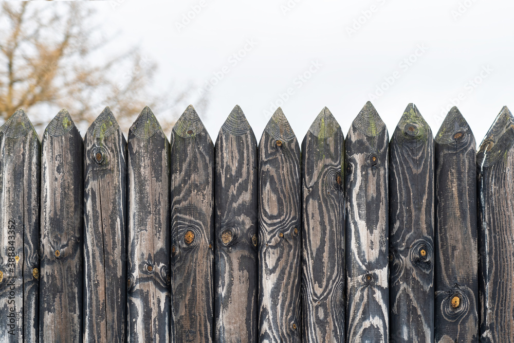 The top of the fence is made of sharpened wooden logs. The structure of ...