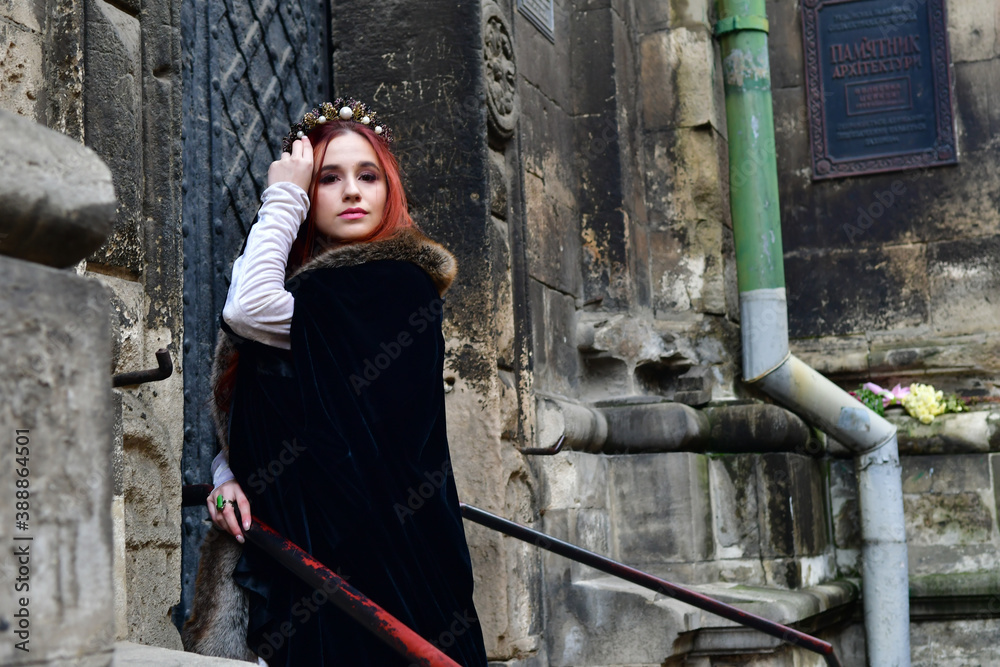 Red-haired princess in a white dress and a black veil with a crown on ...