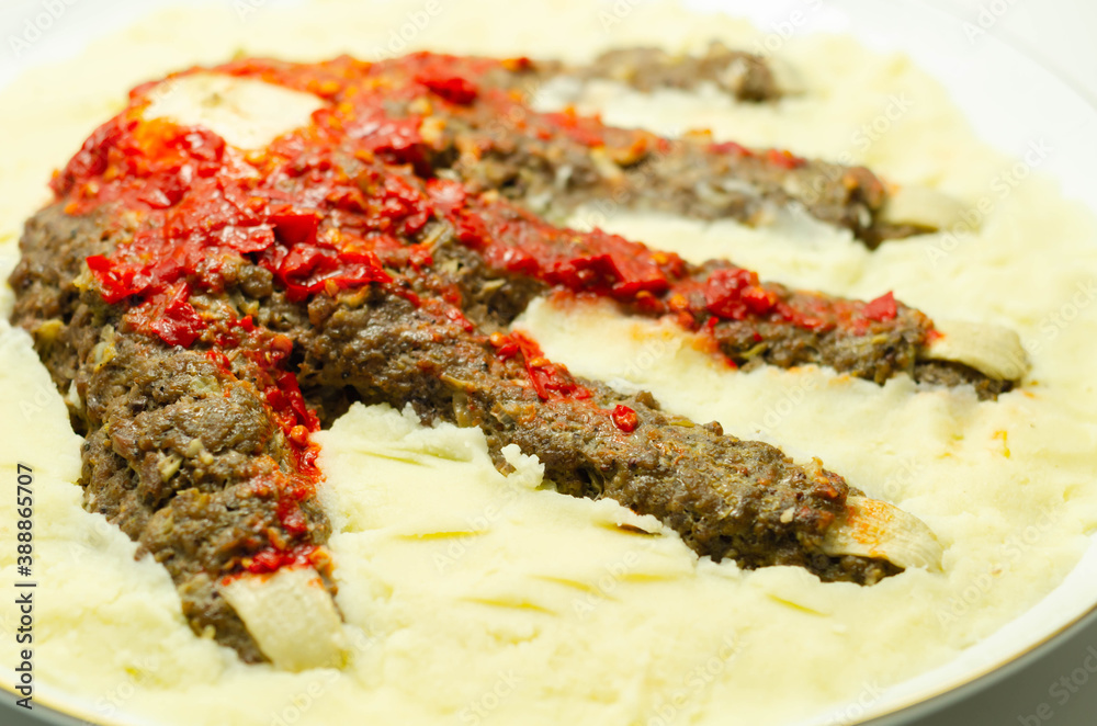 Roasted minced meat formed in the shape of a hand, topped with a tomato ...