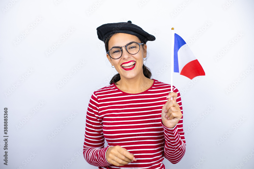 Young beautiful brunette woman wearing french beret and glasses over ...