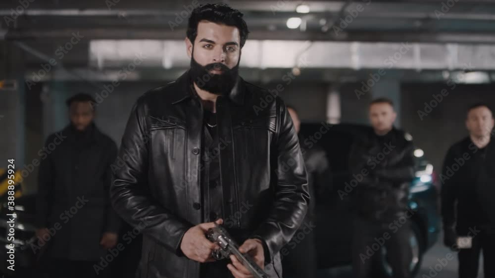 Portrait of bearded Middle Eastern criminal looking at camera while ...