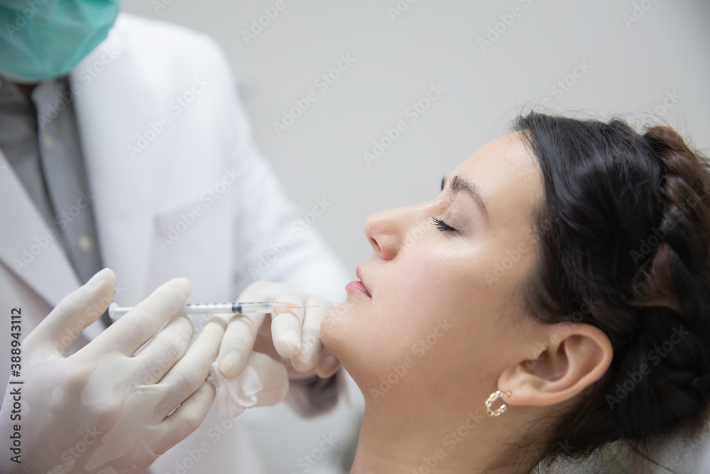 Young woman getting beauty facial injections in salon. Beautician makes ...