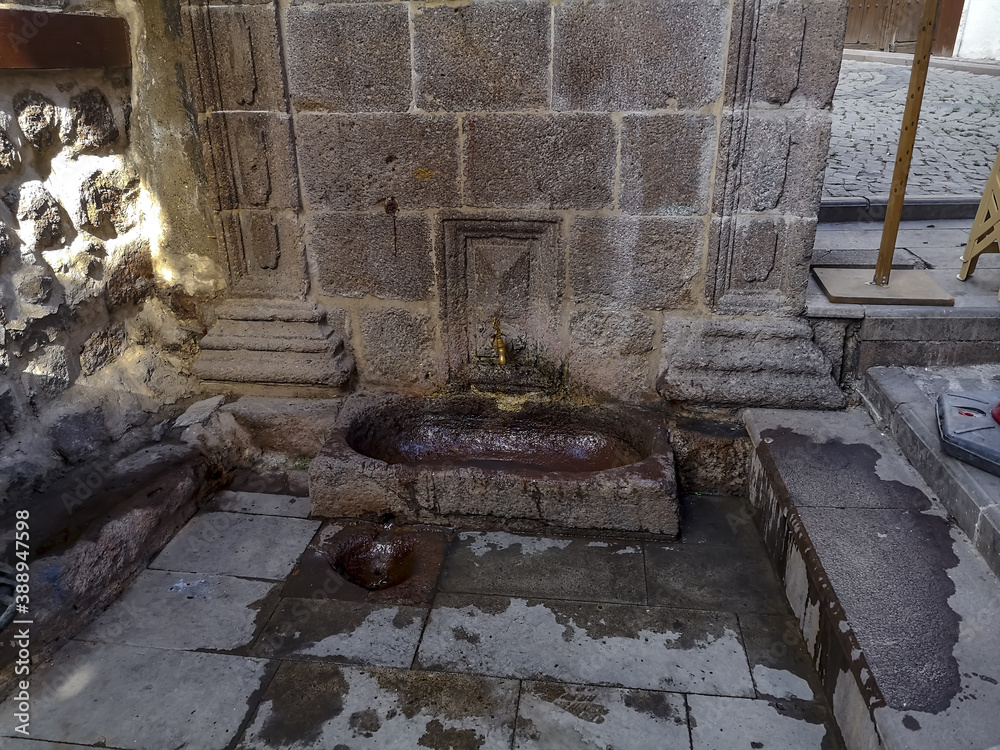 Vintage drinking fountain in an ancient stone wall in Ankara Castle ...
