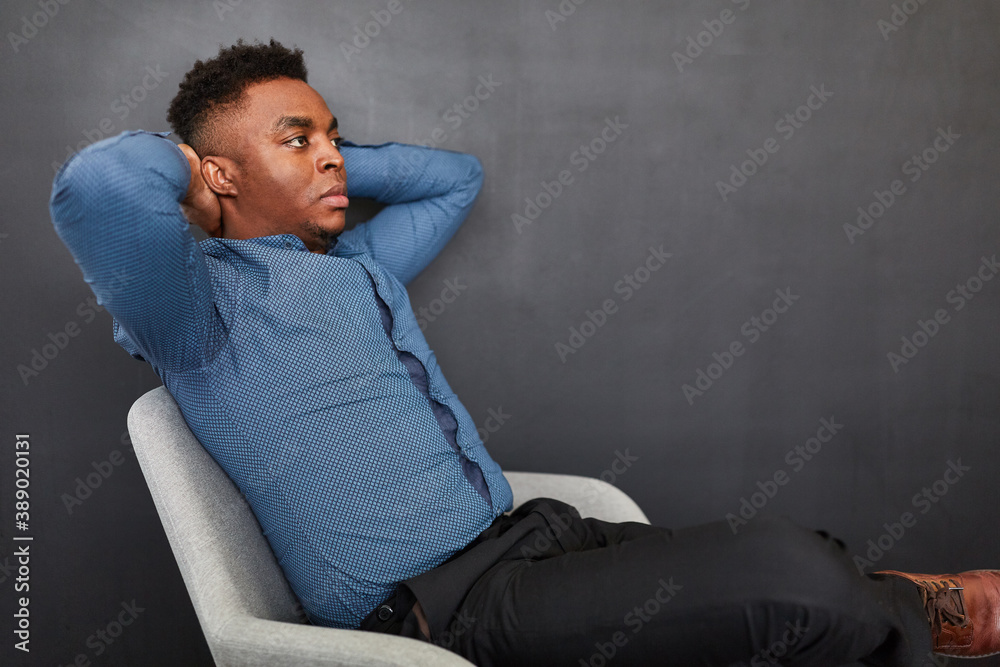 Businessman leans back thoughtfully Stock Photo | Adobe Stock