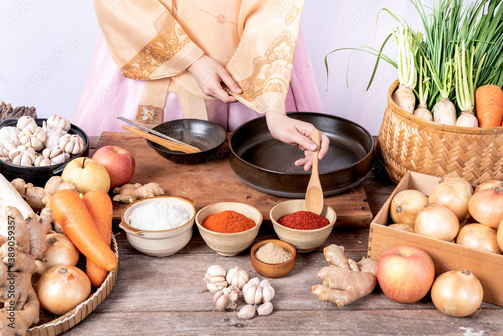 Korean woman is wearing a traditional hanbok, she making Kimchi which ...