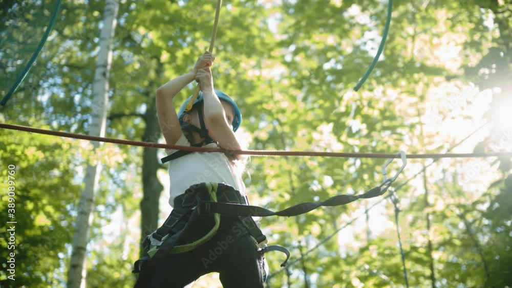 A little smiling girl walking on a rope bridge between the trees Stock ...