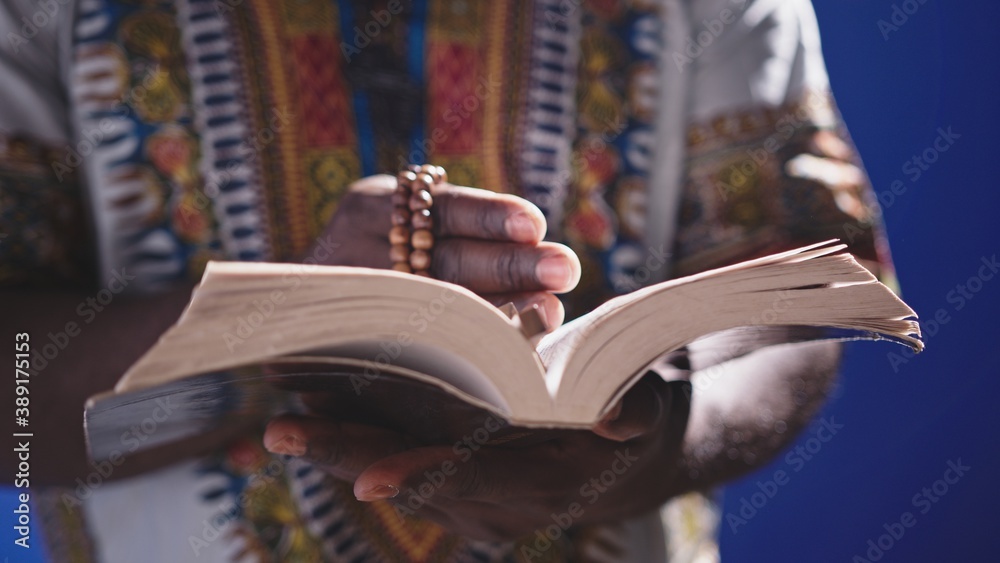 Unrecognizable African black man in traditional dress with rosary ...