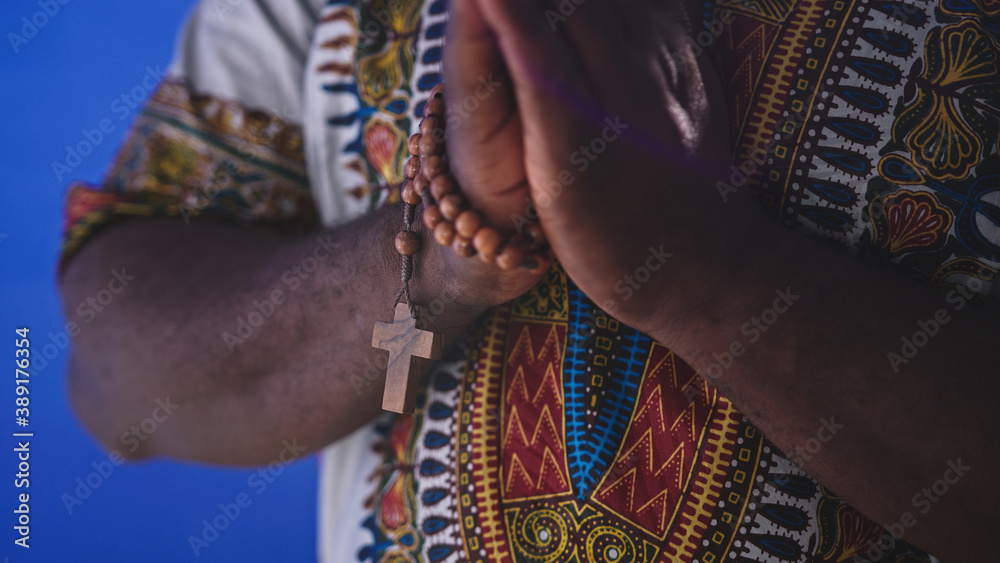 Unrecognizable African black man in traditional dress with rosary ...