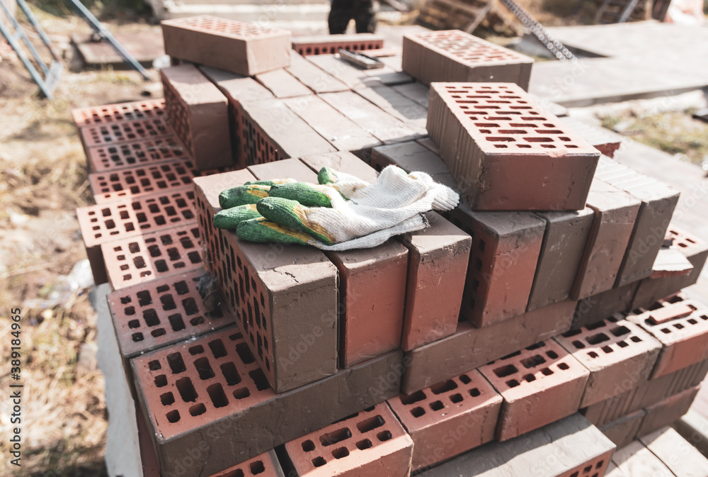 Red burnt brick at a house construction site. Stock Photo | Adobe Stock