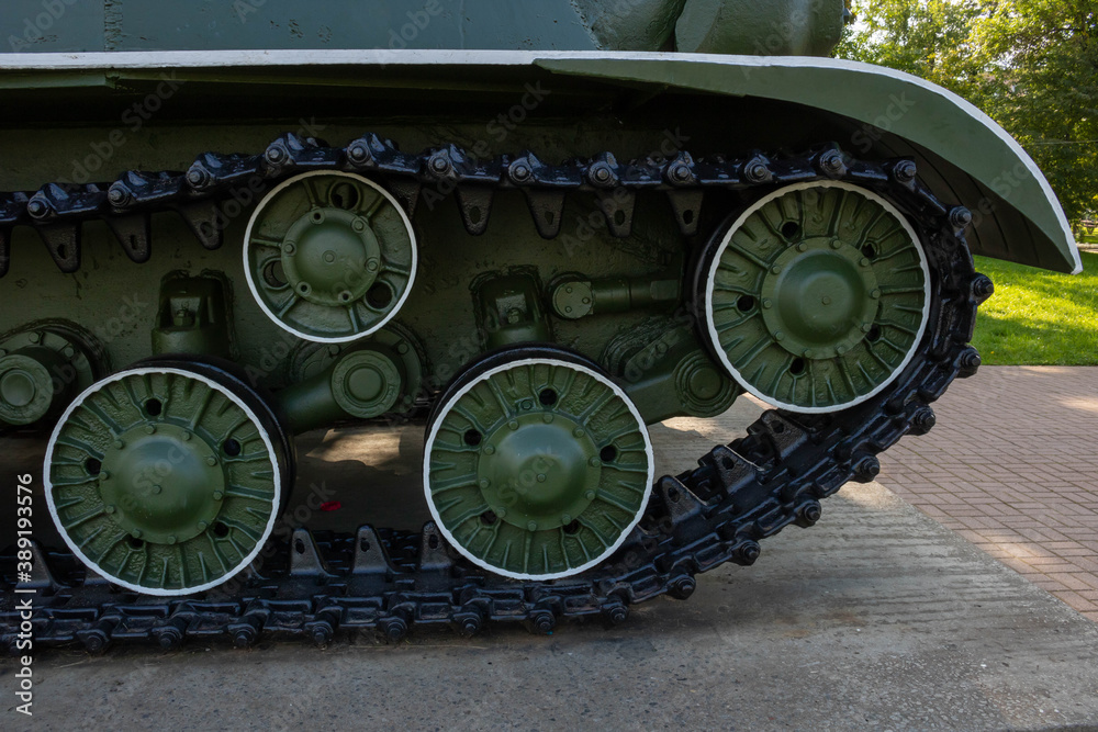 Close-up of the tank chassis. The iron wheels and tracks of the tank's ...