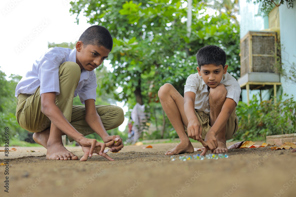 Indian child playing with glass marbles which is an old Indian village ...