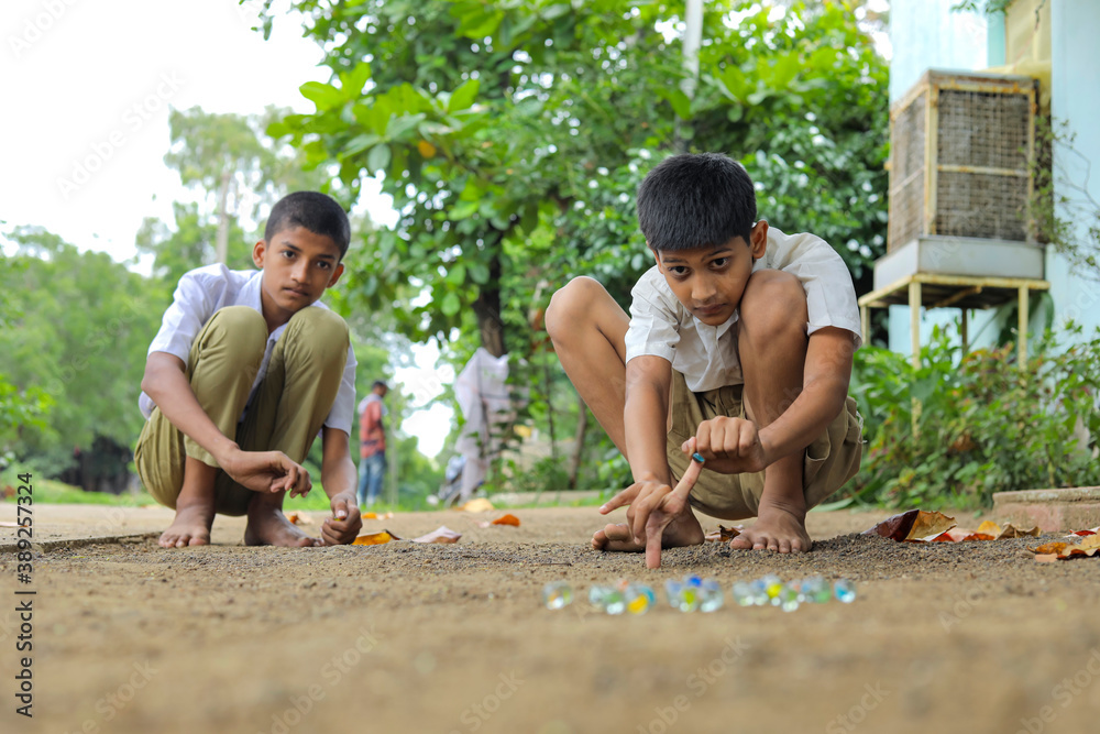Foto de Indian child playing with glass marbles which is an old Indian ...