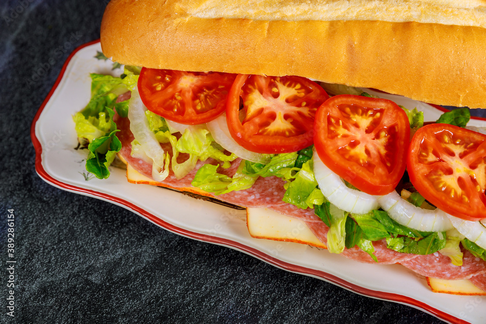 Sub made from french bread, muenster cheese, salami and vegetable ...
