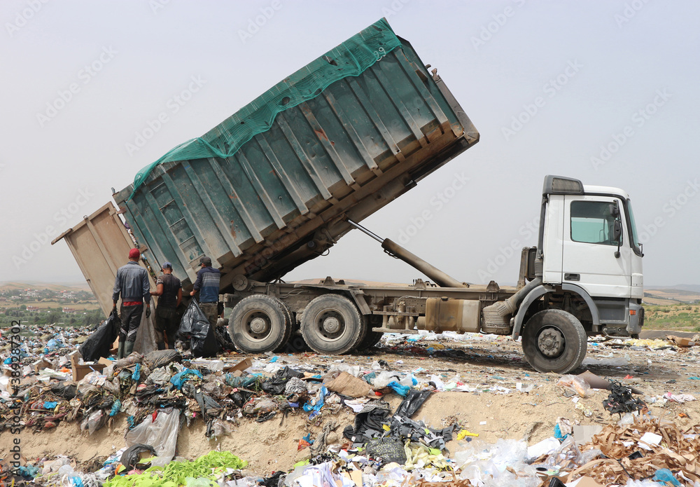 Waste collection truck unloading waste in a sanitary landfill while ...