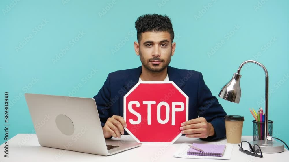 Serious self confident office worker in business suit showing stop sign ...