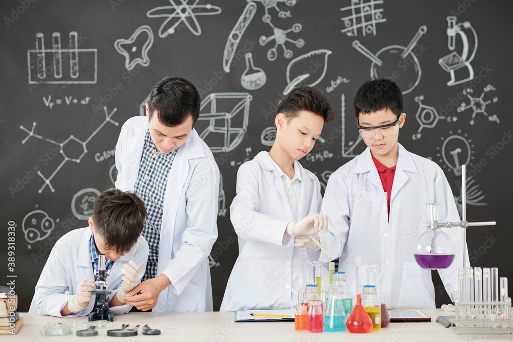 Photo & Art Print School teacher controlling students working with ...