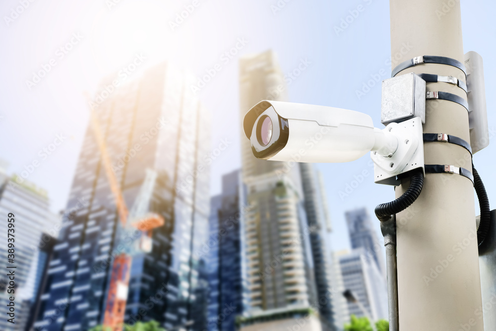 Modern public CCTV camera on electric pole with blur building ...