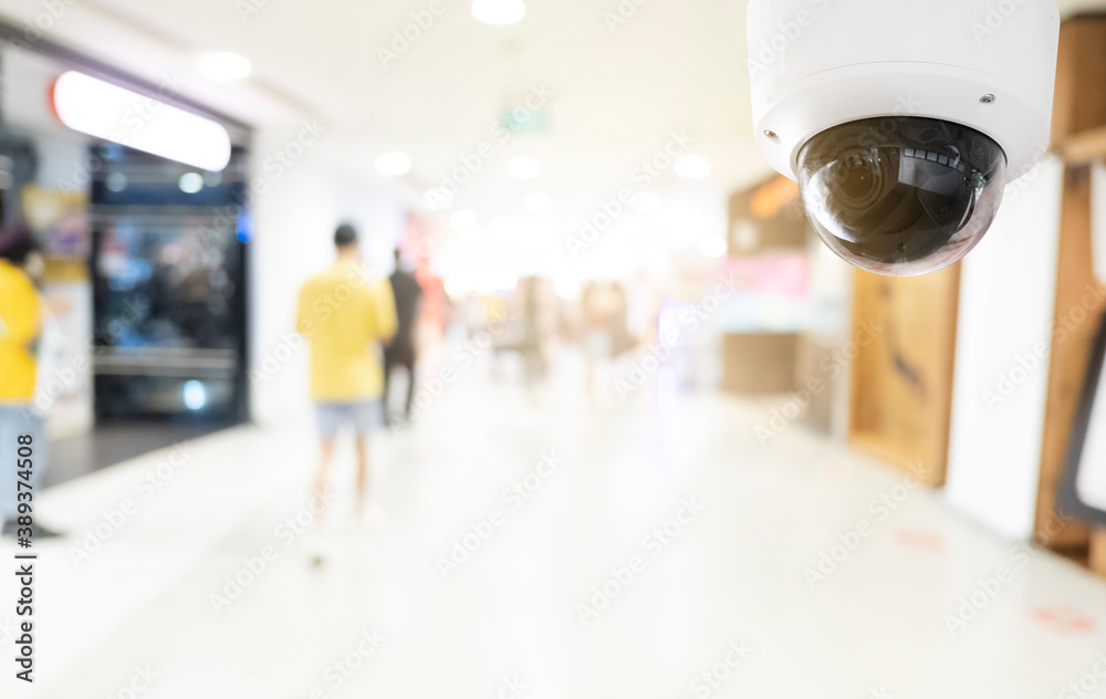 Modern public CCTV camera with blur interior shopping mall background ...