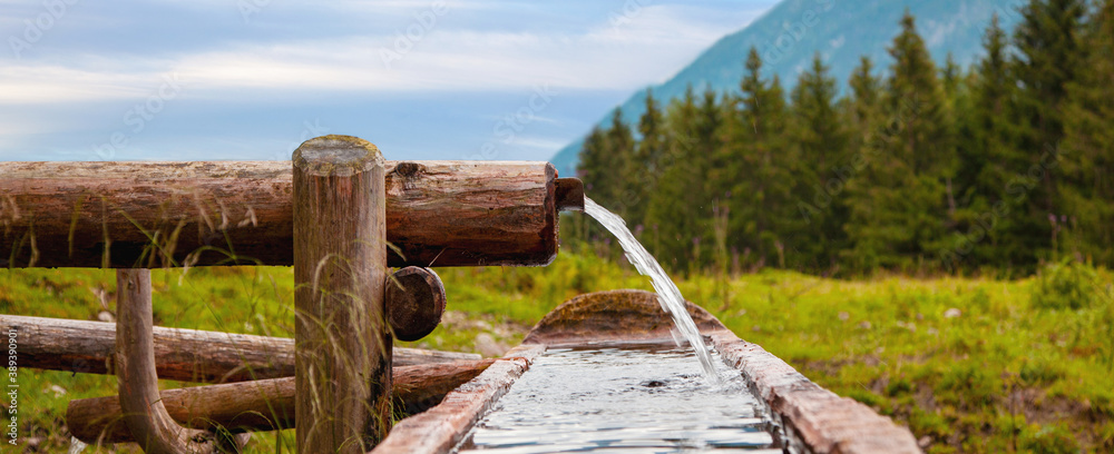 Mountain fountain made from a wooden trunk. Well and Water trough made ...