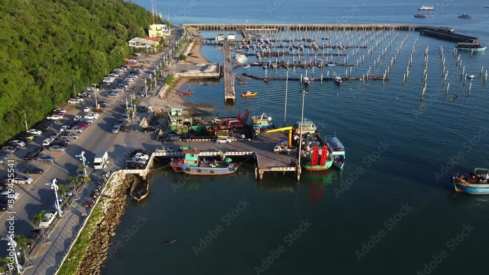 Fly and camera tilt over small unloading pier and speedboat moorings ...