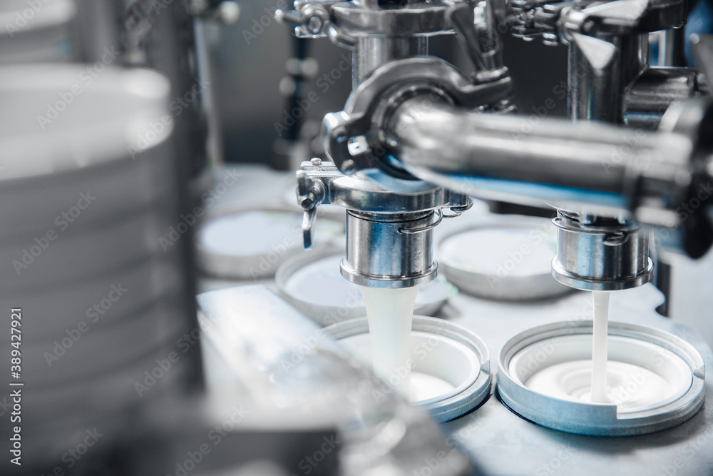 Automated filling of yoghurt into packages. Food production, dairy ...