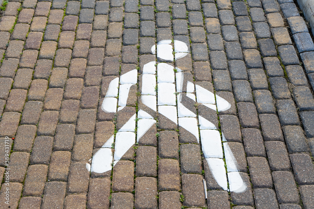 Footpath with pedestrian sign painted on paving slabs. Sidewalk sign ...